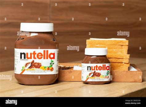 Nutella With Large And Small Bottles And Some White Bread Neatly