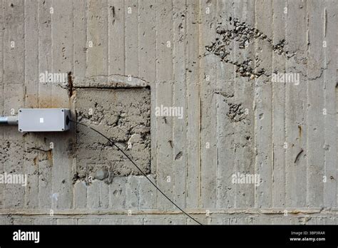 Weathered Concrete Wall Features Rectangular Patch With Exposed Rebar