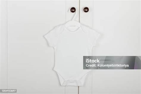 옷걸이에 아기 귀여운 흰색 바디 수트 흰색 배경입니다 아기 옷 로고 광고의 디자인 및 배치를 위해 모의 0명에 대한 스톡 사진