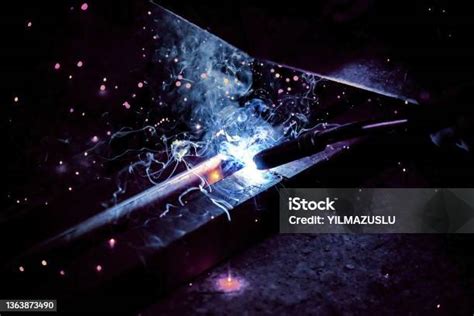 A Welder Welds Metal Into His Workshop Blue Welding Sparks Gas