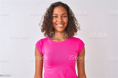 분홍색 티셔츠를 입은 젊은 브라질 여성이 얼굴에 행복하고 시원한 미소를 지으며 고립 된 흰색 배경 위에 서 있습니다 운이 좋은 사람 T 셔츠에 대한 스톡 사진 및 기타