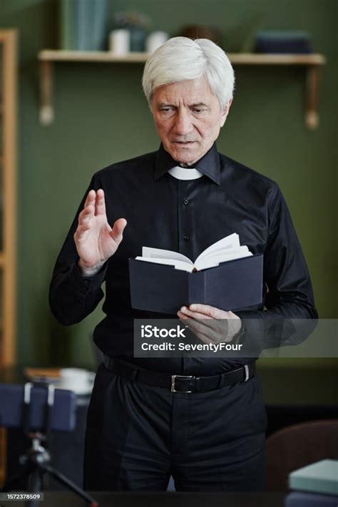 성경을 들고 사무실에서 온라인 블로그를 위한 비디오를 녹화하는 원로 사제 55 59세에 대한 스톡 사진 및 기타 이미지 55 59세 Brand Name Smart
