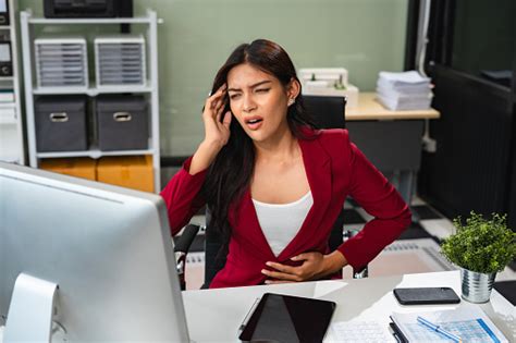 설사 또는 변비 건강 개념에 대한 문제 클로즈업 여자 책상에 앉아 두통 복통 복부 질환 및 질병을 가진 손으로 만지는 복통을 느낍니다 20 24세에 대한 스톡 사진 및 기타