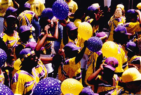 노란색 파란색 보라색 옷 모자 풍선을 들고 카니발 블록에 모인 한 무리의 사람들이 브라질 상파울루의 거리를 지나가며 대비가 뚜렷합니다 Carnival에 대한 스톡 사진 및