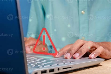 Man Using A Laptop With Red Triangle Caution Warning Sign For