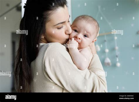 Mother Kissing Baby Boy At Home Stock Photo Alamy
