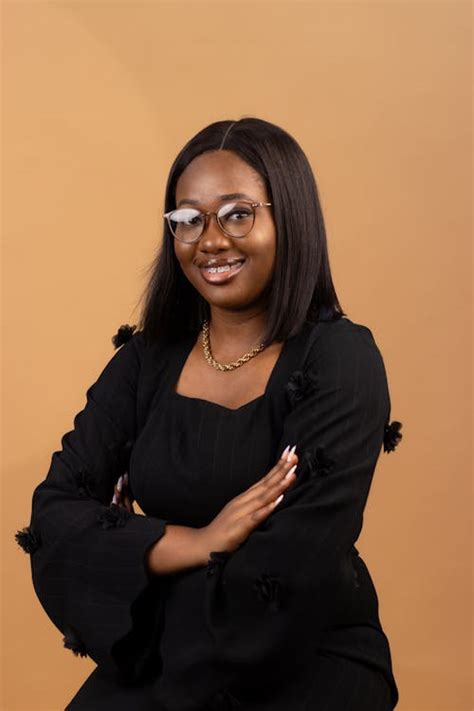 안경과 자연스러운 머리카락으로 웃는 자신감 넘치는 여성 · 무료 스톡 사진