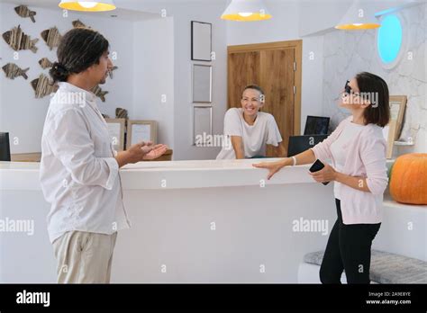 Smiling Woman Guest Near Reception Desk Friendly Man And Woman Hotel Workers Stock Photo Alamy