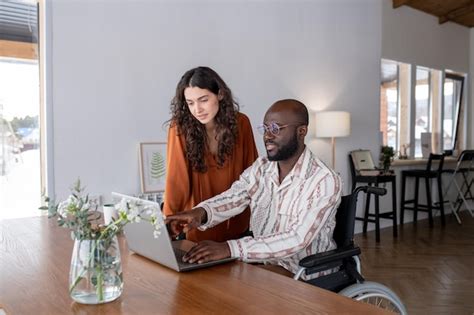Premium Photo Young Man With Disability Pointing At Laptop Screen During Presentation