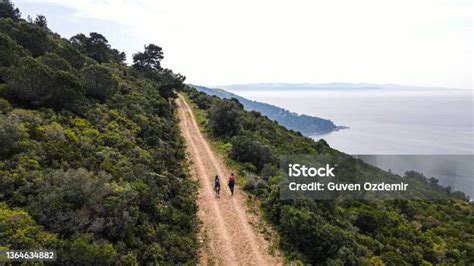 열대 우림의 산악 경사면을 걷고 있는 여성과 남성의 공중 보기 해변가숲 길하이킹 남녀 숲 트레킹 숲 길을 따라 걷는 사람들 위에 공중 무인 항공기 비행 공중 뷰에 대한 스톡