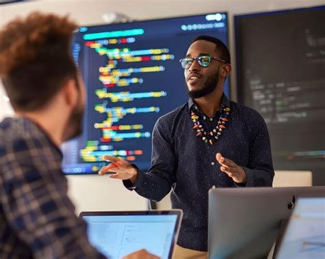 confident male programmer presenting project to colleagues in