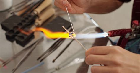 젊은 여성 전문 램프 작업자의 손은 작업장이나 스튜디오에서 버너 위에 유리 공작물을 들고 불로 태우고 있습니다 사진 Unsplash의 창조성 이미지