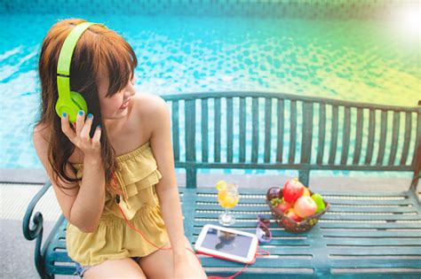 기쁘게 여자 헤드폰으로 음악을 듣고 수영장 옆에 빨간 사과를 먹고 행복 하 고 미소 개념 건강한 생활방식에 대한 스톡 사진 및 기타 이미지 Istock