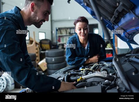 Team of mechanics examining car engine Stock Photo - Alamy