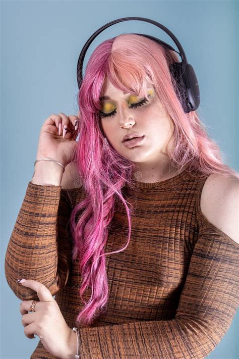 Non Binary Woman Listening To Music With Wireless Headphones Stock
