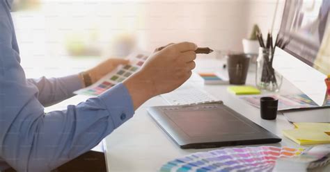 그래픽 디자이너는 테이블과 아침 조명에서 디지털 태블릿과 마우스 펜으로 작업합니다 사진 Unsplash의 사무실 이미지