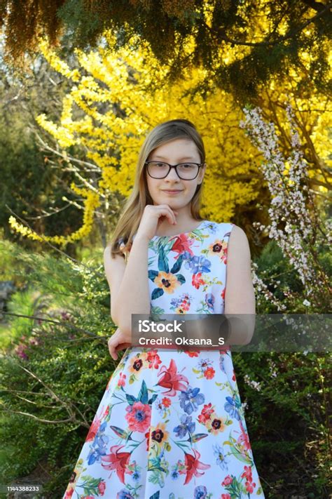 안경 및 갈색 머리를 가진 아름 다운 소녀의 초상화입니다 잔디와 꽃 사이에서 휴식 하는 녹색 봄 공원에서 젊은 웃는 Teneeger 라이프 스타일 피플 컨셉 갈색에 대한