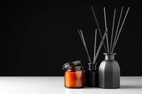 Premium Photo Black Reed Diffuser And Candle On Grey Surface Against Black Background