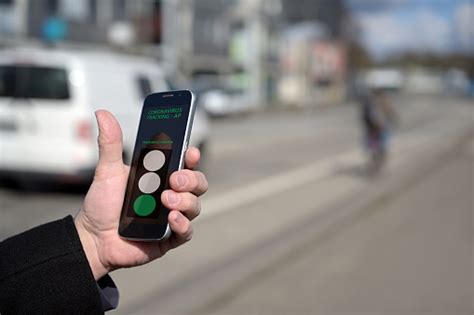 사람의 손은 사람들 사이의 접촉을 모니터링하고 감염의 위험을 보여줍니다 코로나 바이러스 추적 응용 프로그램과 함께 자신의 스마트 폰을 확인하고 흐릿한 도시 거리 배경 복사