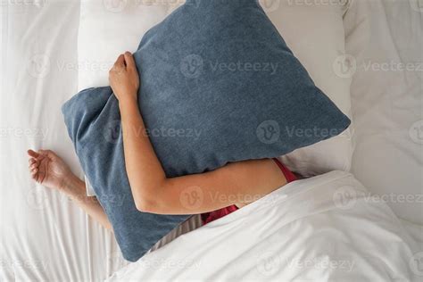 Scared Woman In Bed Covering Herself With A Pillow Her Head 69344245