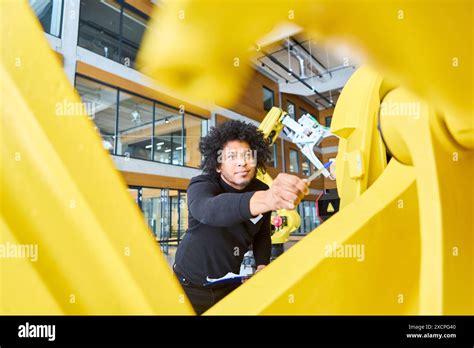 Engineer Working On Programming A Robot Equipped With A Gripper Arm In