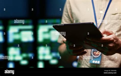 Serviceman Verifying Maintenance Checklist In High Tech Facility