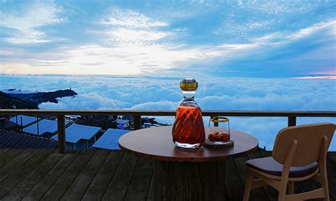 나선형 디자인이 있는 투명한 병에 담긴 위스키 나 브랜디와 나무 테이블이나 나무 껍질에 투명한 유리가 놓여 있습니다 아침에 산의 경치에 안개가 낀 풍경 3d 렌더링 0명에