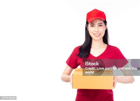 흰색 배경에 고립 된 빨간색 유니폼을 입은 배달 여성이 공간을 복사합니다 모자를 쓴 여성 택배로 일하는 티셔츠 또는 소포 상자를 들고 있는 딜러 패키지 전송 배송 서비스 및