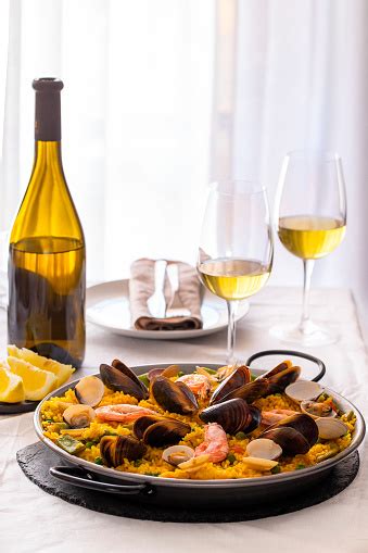 해산물 빠에야 화이트 와인과 함께 제공되는 전통 프라이팬에서 유명한 스페인 쌀 요리 분홍색 새우 조개 홍합을 곁들인 파에야