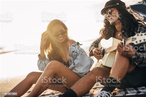 해변에서 자신의 여자 친구에게 어쿠스틱 기타를 연주하는 남자 2명에 대한 스톡 사진 및 기타 이미지 2명 기타 현악기 긴