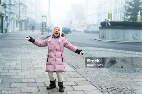 귀여운 Liitle 슬픈 따뜻한 긴 분홍색 재킷과 오래된 유럽 도시 웰스의 빈 거리에 큰 소리로 외치는 모자에 백인 소녀를 잃었다 백라운드에 아침 안개에 마을에서 혼자