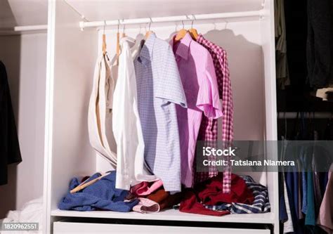 지저분한 옷장 펼쳐진 남자의 옷 흩어진 물건 옷걸이에 걸린 셔츠가 매달려 있는 옷장 정크 서랍 그 엉망 개념을 청소하고 옷장 솔루션 수평면을 정리하십시오 0명에 대한 스톡