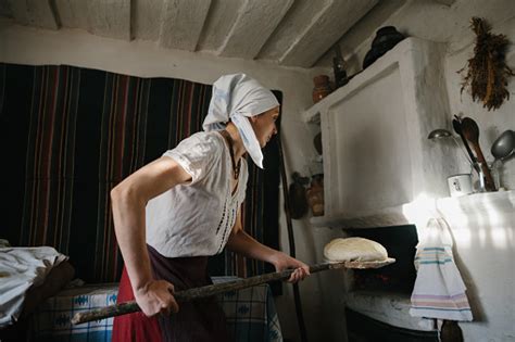 한 여자 빵 굽는 사람이 생빵을 장작 화덕에 넣고 있다 우크라이나 마을의 정통 빵 굽는 장면 35 39세에 대한 스톡 사진 및