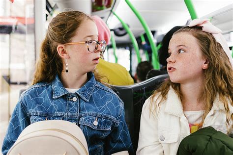 Tween Girls Talk Together On Public Transportation Bus In England