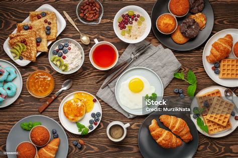 위에서 캡처 한 유럽식 아침 식사 커피 차 크루아상 잼 계란 팬케이크 마핀 오트밀 나무 배경입니다 가족 아침 식사 테이블입니다 가족에 대한 스톡 사진 및 기타 이미지