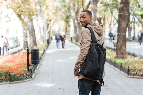 Premium Photo Young Happy Man Wearing Backpack Walking On The Street