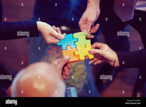 Business People Group Assembling Jigsaw Puzzle And Represent Team