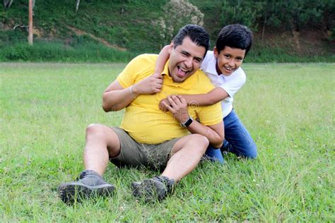 Dad And Dark Haired Latin Son 9 Years Old Play In The Park And Have Fun Spend Quality Time