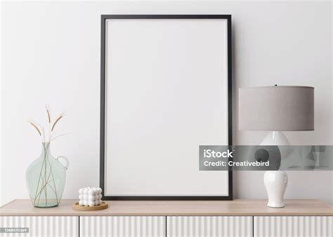 현대 거실의 흰색 벽에 빈 수직 사진 프레임 현대적인 스타일로 인테리어를 모의 사진 포스터를위한 여유 공간 콘솔 램프 잔디 촛불이있는 유리 꽃병 3d 렌더링 0명에 대한