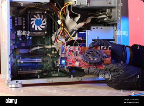 Disassembly Of A Graphics Card From An Old Computer By A Person On A Table And A Pink Background