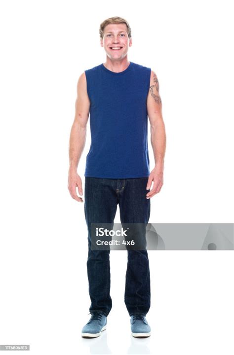 전체 길이 정면 1명 2029세 성인 잘생긴 사람 코카서스 남성 젊은 남성 서 탱크 탑 청바지 바지 캔버스 신발 웃고 있는 행복