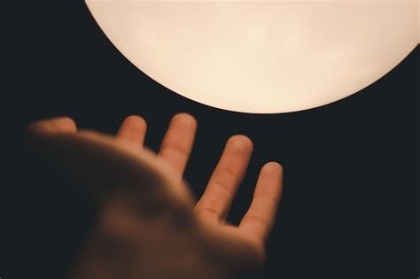 Premium Photo Close Up Of Hand Holding Illuminated Lamp