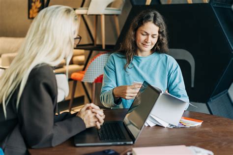 한 여성 고객이 디자인 선택에 대해 관리자와 상의합니다 두 명의 여성 사업가가 일하고 있습니다 2명에 대한 스톡 사진 및 기타