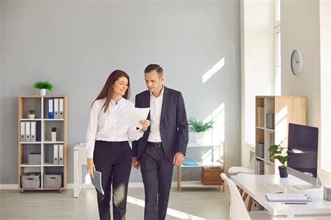 사무실에서 회의를 하는 동안 동료에게 문서를 보여주는 웃는 친절한 사업가 남자에 대한 스톡 사진 및 기타 이미지 남자 관리자 보조원 Istock