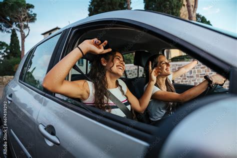 Foto De Two Young Women Sing A Song On The Radio And Dance In The Car