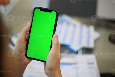 Phone green screen in hand, hand holding smartphone green screen in house, using mobile phone ...