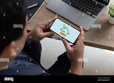 Businessman Use Phone Energy Efficiency Mobile App On Screen Chart And House Stock Photo Alamy