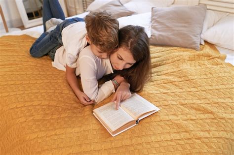 Mãe E Filha Lendo Um Livro Na Cama Foto Grátis