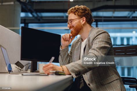 노트북으로 작업하고 사무실 배경에 책상에 앉아 메모를 하는 잘생긴 사업가 20 24세에 대한 스톡 사진 및 기타 이미지 20 24세 경영자 고용과 노동 Istock