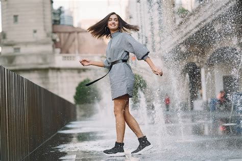 Menina Brincando E Dançando Em Uma Rua Molhada Foto Grátis
